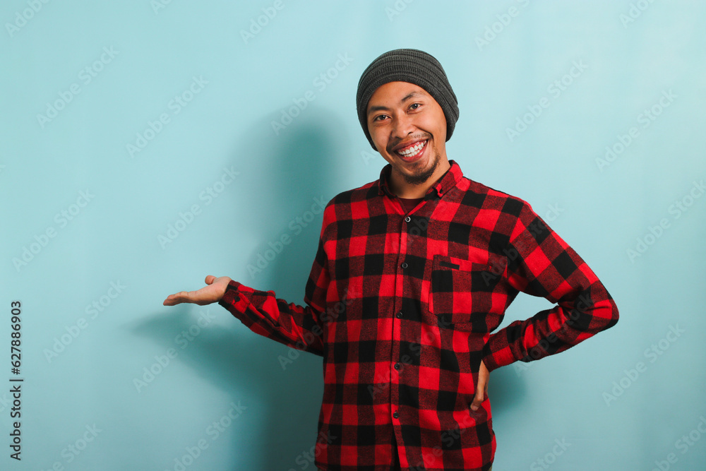 Smiling young Asian man with a beanie hat and a red plaid flannel shirt ...