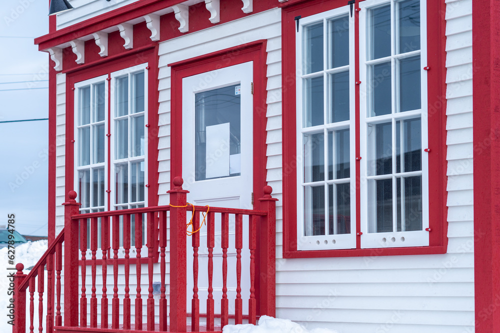 The exterior of a vintage convenience store with multiple large glass ...