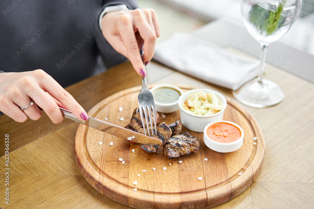 Lunch in a restaurant, a woman eats Pieces of liver cooked on the grill ...