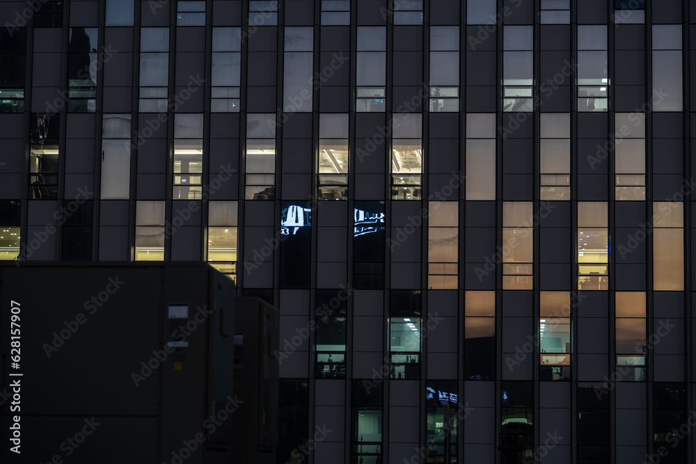 Offices seen through illuminated windows after sunset, modern city ...