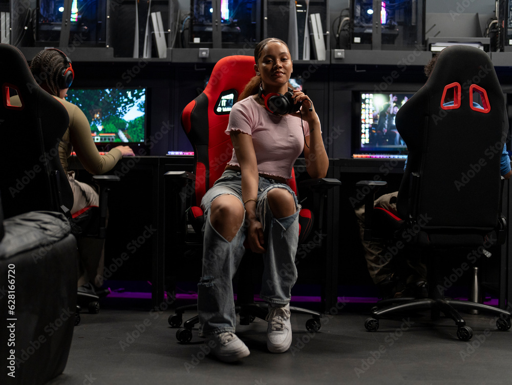 Photo Young gamer looking at camera while friends playing video games ...