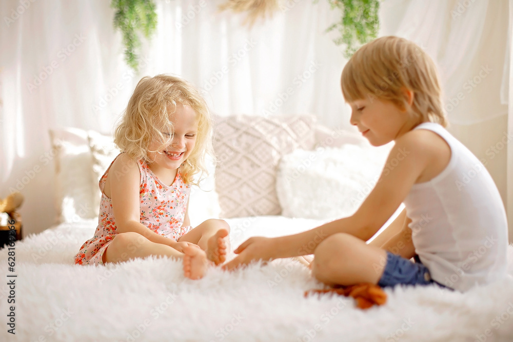 Cute sweet toddler children, tickling feet on the bed, laughing and ...