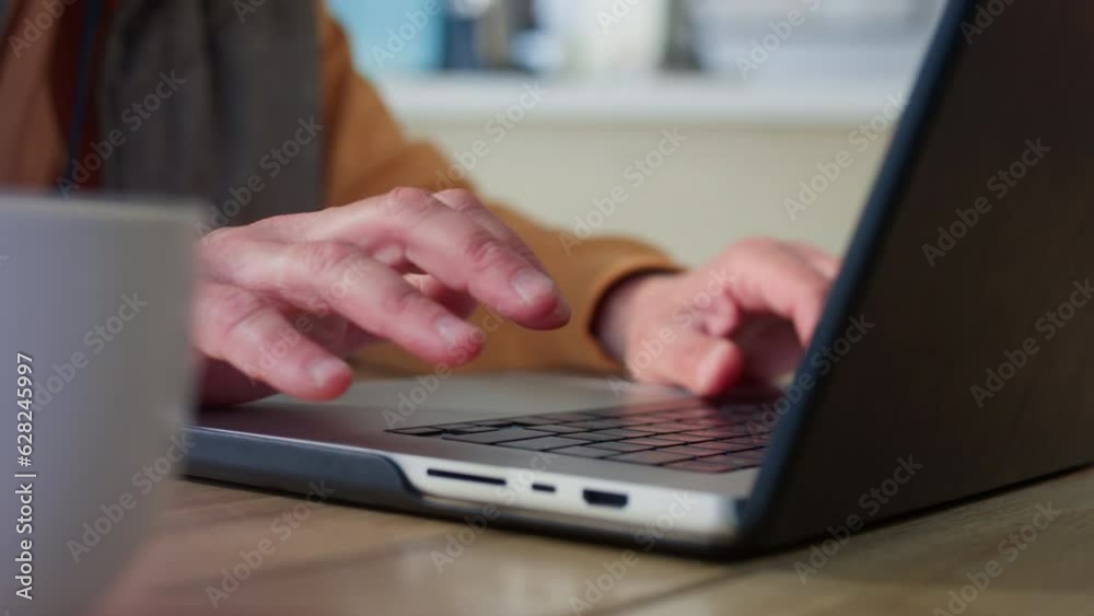 The old man is working on a laptop. A pensioner types with his fingers ...