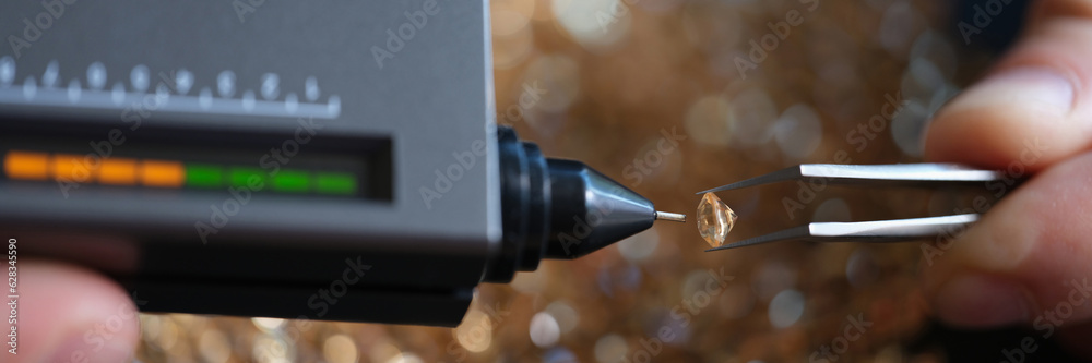 Specialist evaluates quality and cost of diamonds using special device ...