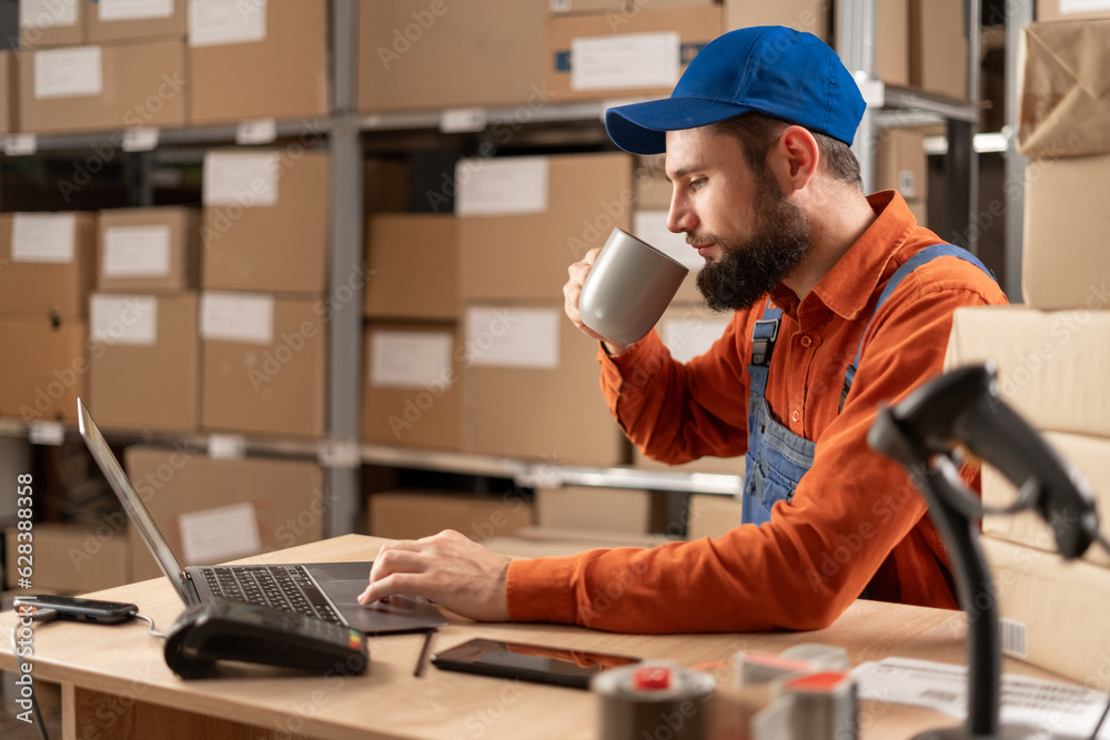 Professional male worker using laptop computer checking stock and ...