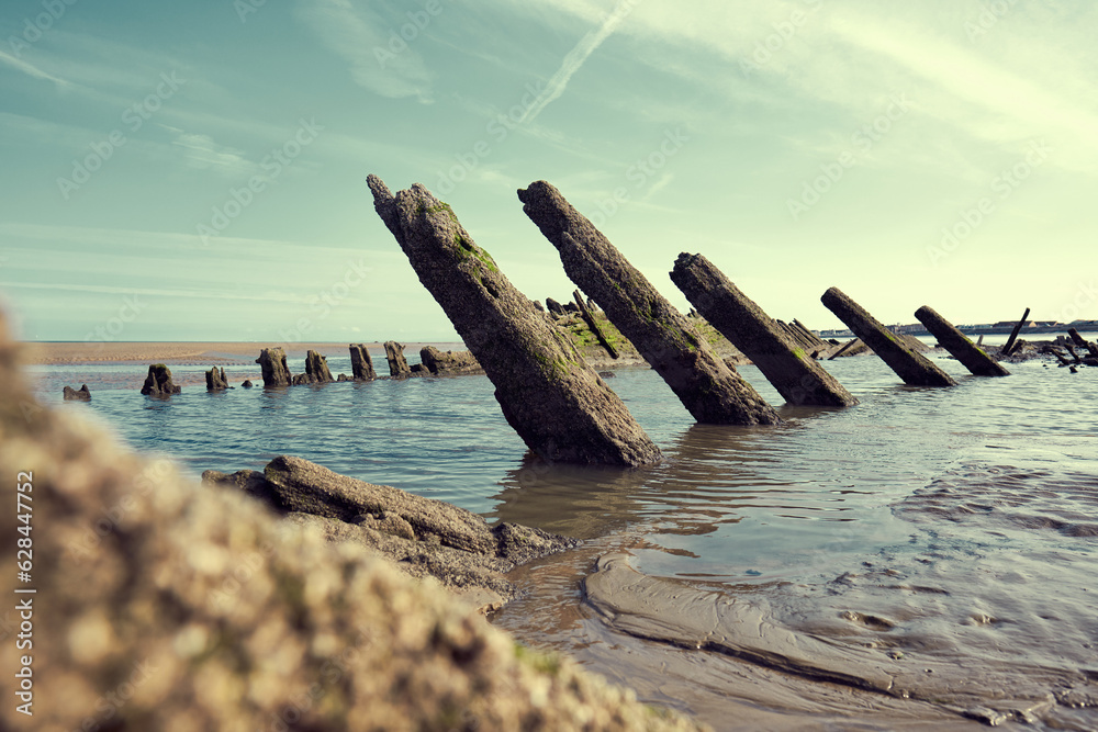 An old historic wooden shipwreck vessel carcass exposed on a desolate ...
