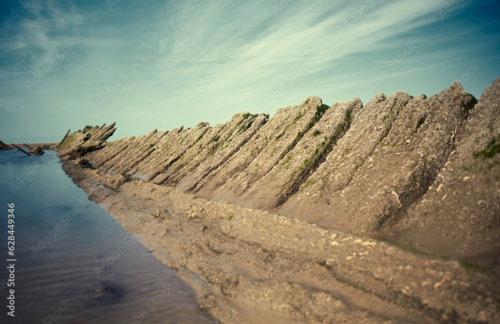 An old historic wooden shipwreck vessel carcass exposed on a desolate ...