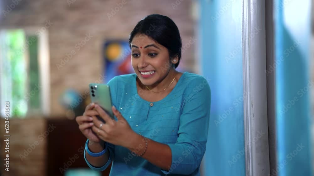 An Indian woman joyfully video-calling, balancing household chores, or ...