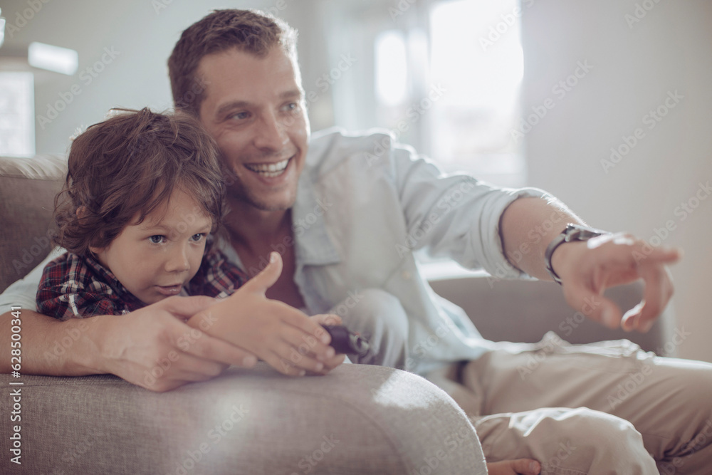 Father and son watching tv in the living room at home Stock Photo | Adobe Stock