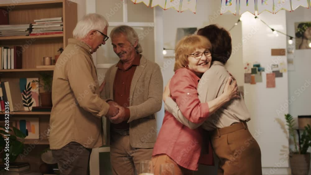 Medium shot of cheerful elderly friends cuddling each other when ...