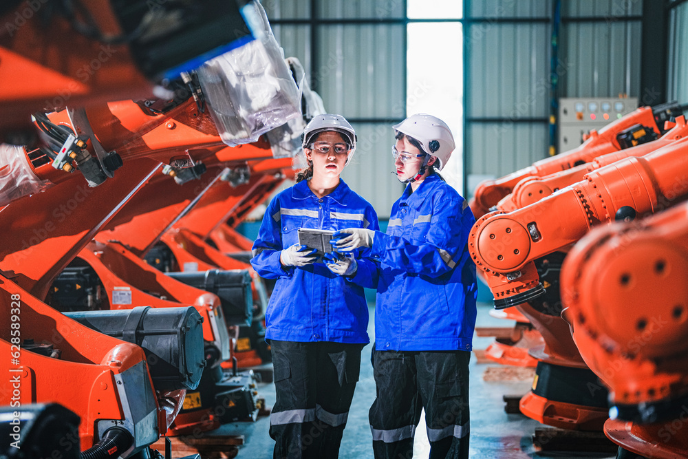 Factory engineer woman inspecting on machine with smart tablet. Worker ...