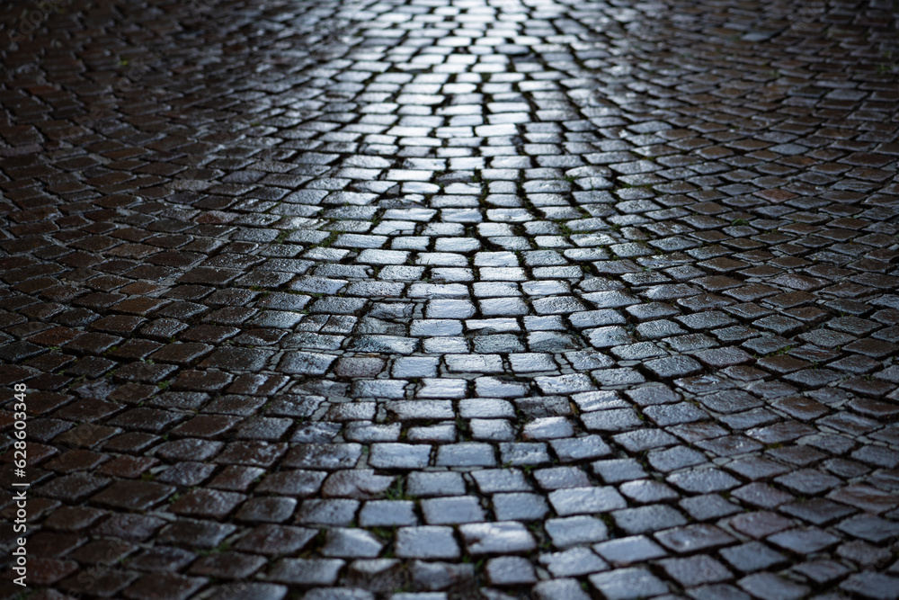 Cobblestone in a narrow street in Stresa, Italy. Wet shiny historic ...