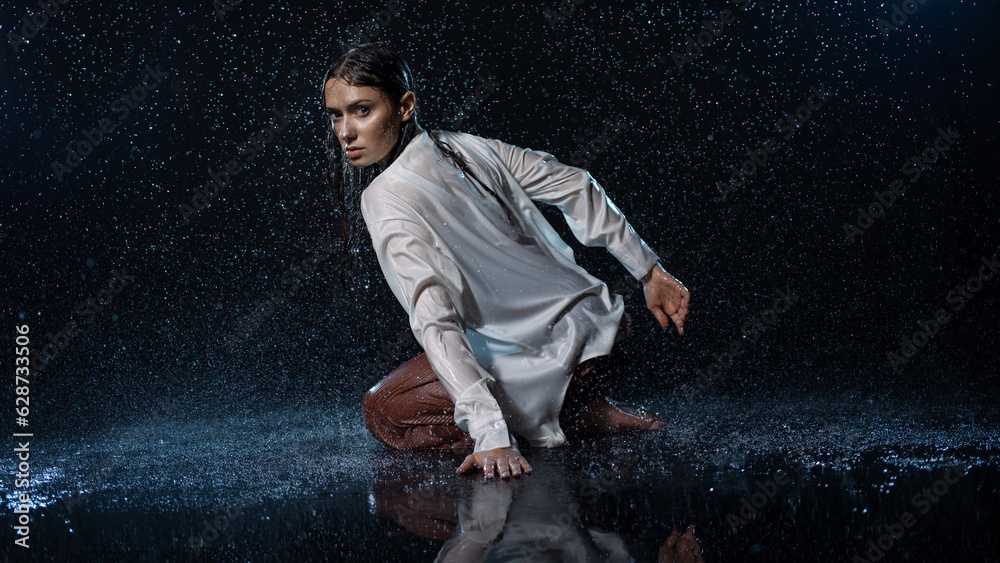 young woman in the rain, getting wet through, wet clothes and water ...