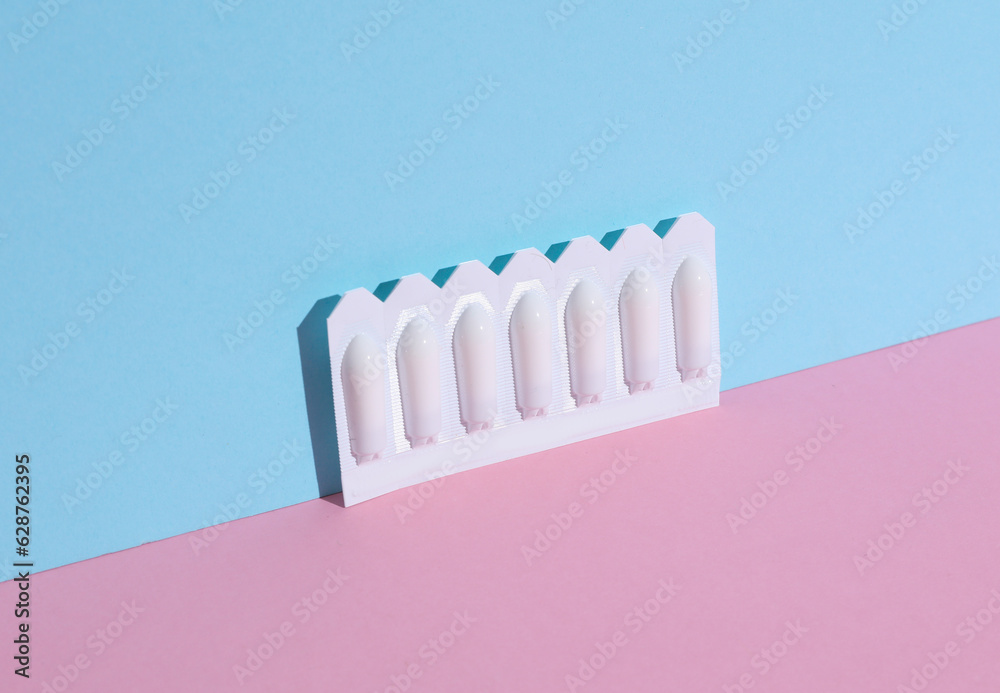 Blisters of vaginal suppositories on a pink blue background. Creative ...