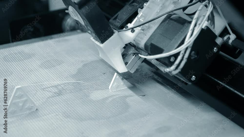 3D printer printing prototype of toy from molten plastic. Process of ...