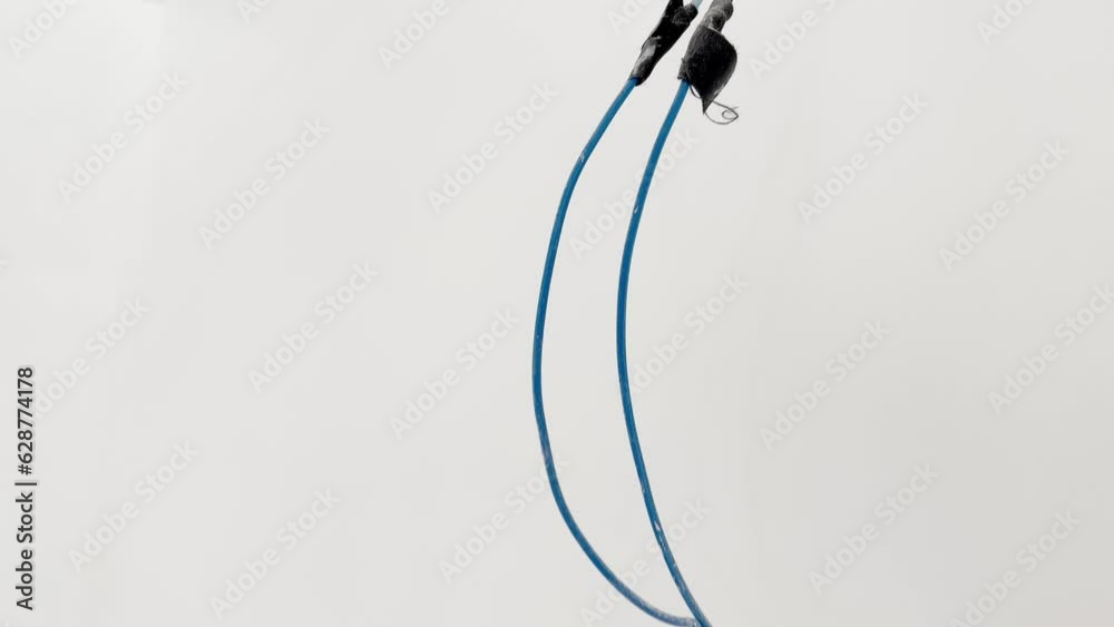 A long electrical wire sticks out of a white wall during a renovation ...