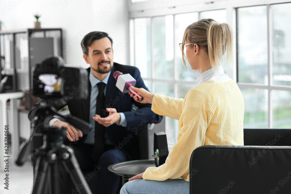 Female journalist with microphone having an interview with man on ...