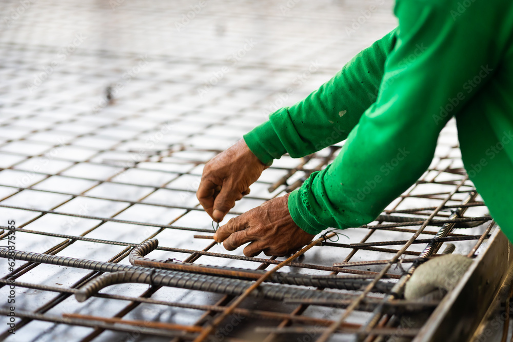 Reinforced concrete structures. Construction worker uses pilers tools ...