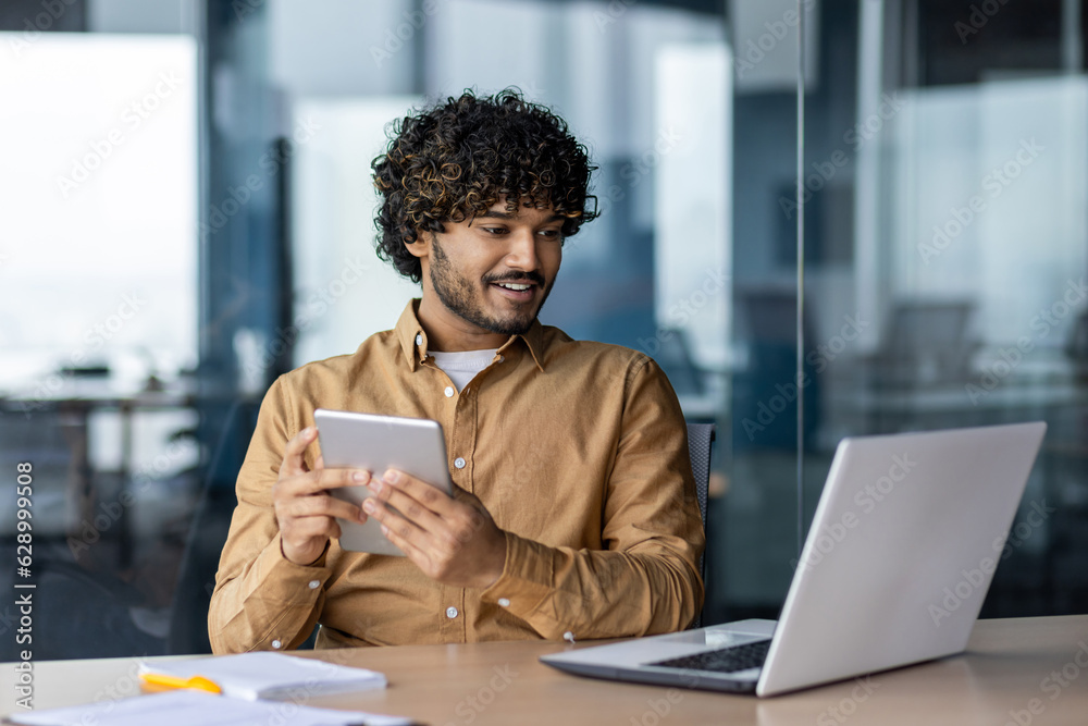 Young successful hispanic man with tablet computer, satisfied with ...