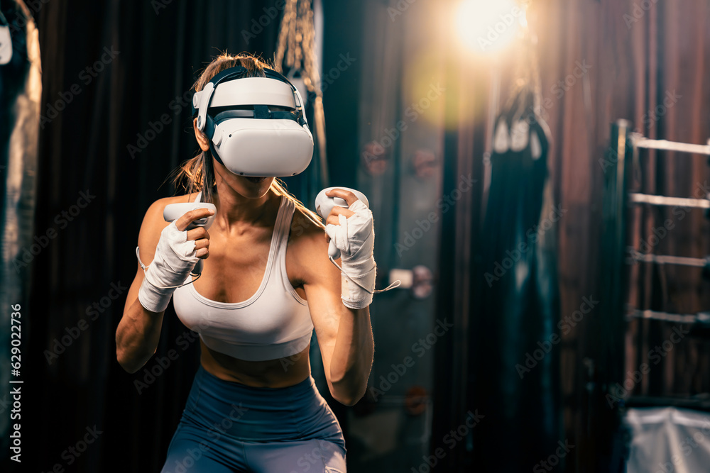 Female boxer training with VR or virtual reality, wearing VR headset ...