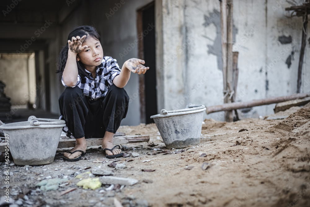 Exhausted child girl sitting construction background. child labor and ...