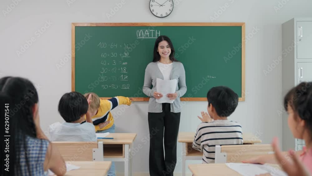 Smart caucasian cute boy writing answer math formula on blackboard with ...