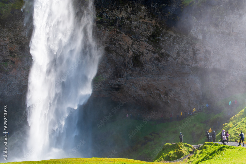 Seljalandsfoss Waterfall - People walking towards the waterfall in ...
