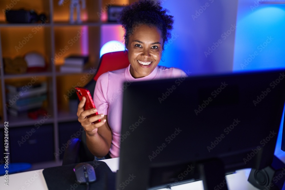 African american woman streamer using computer and smartphone at gaming ...