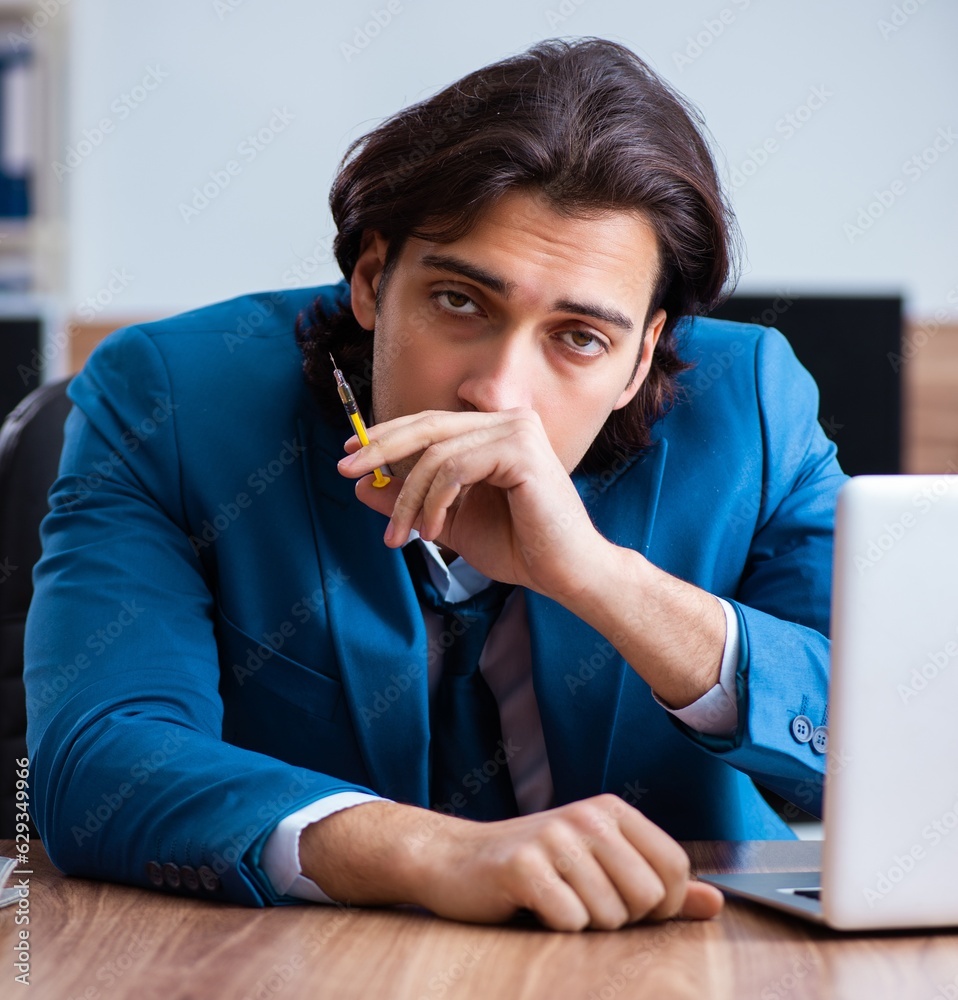 Young man having problems with narcotics at workplace Stock Photo ...