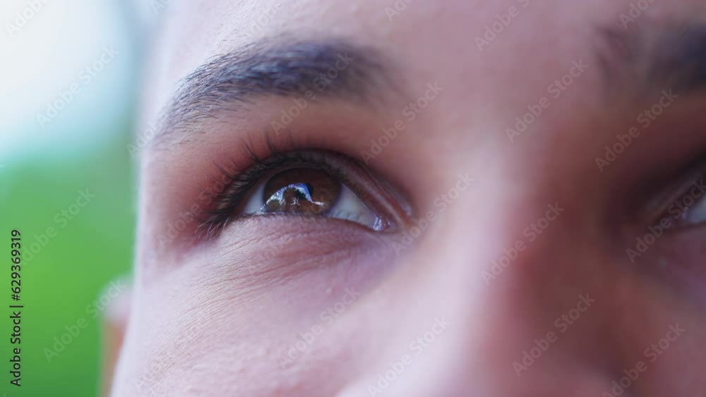 Macro close-up of a young black man gazing upwards at sky, detail of ...