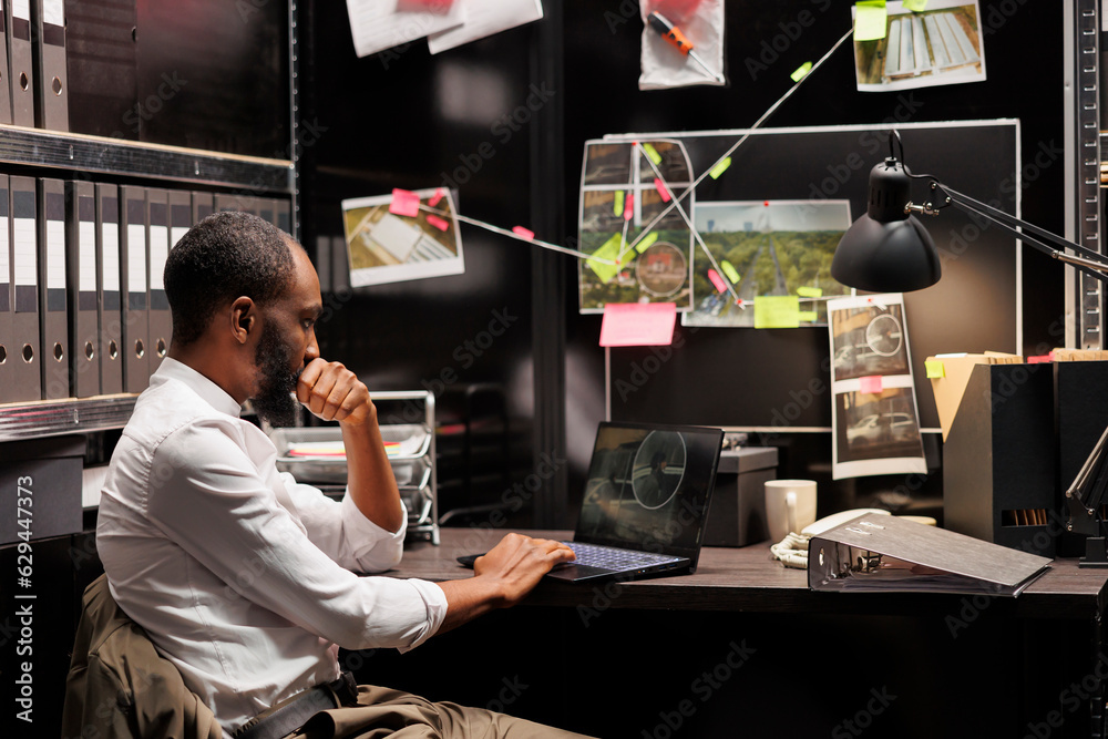 Private detective wathing cctv camera photos on laptop while sitting at ...