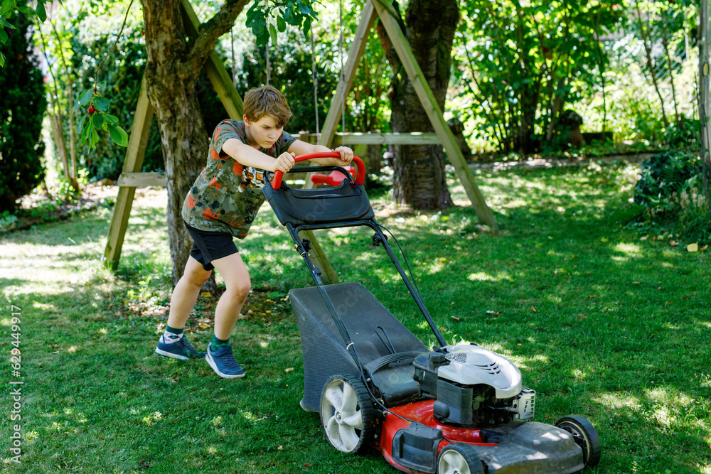 Happy preteen kid boy with lawn mower. Portrait of smiling teenager ...