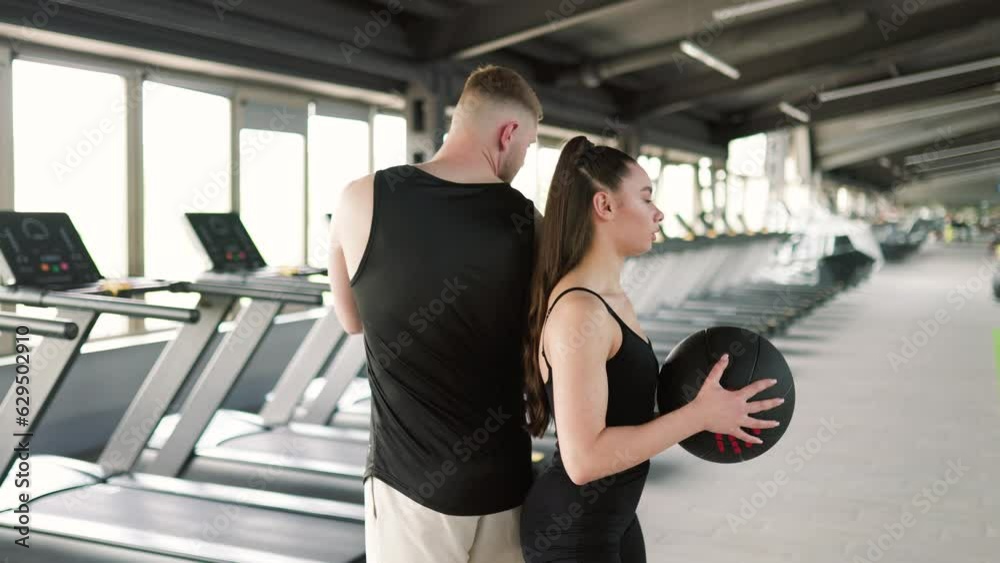Dynamic Workout Duo A man and woman engage in a challenging fitness ...