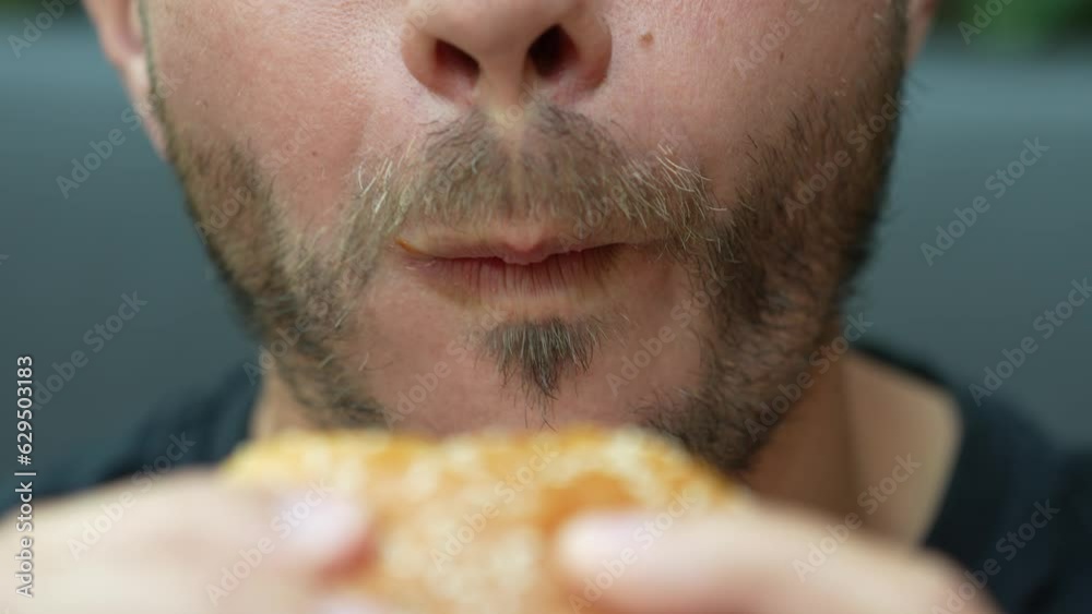 Man eating burger in restaurant. Close up shot of male biting hamburger ...