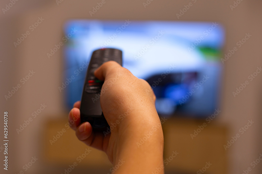 Hand holding TV remote control Stock Photo | Adobe Stock
