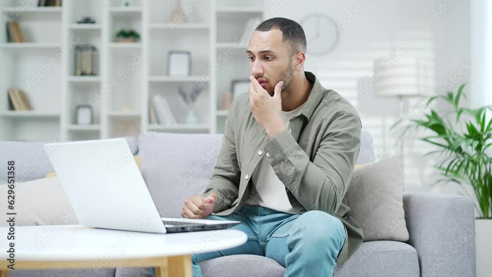 confused young man receiving message with bad news reading notification ...