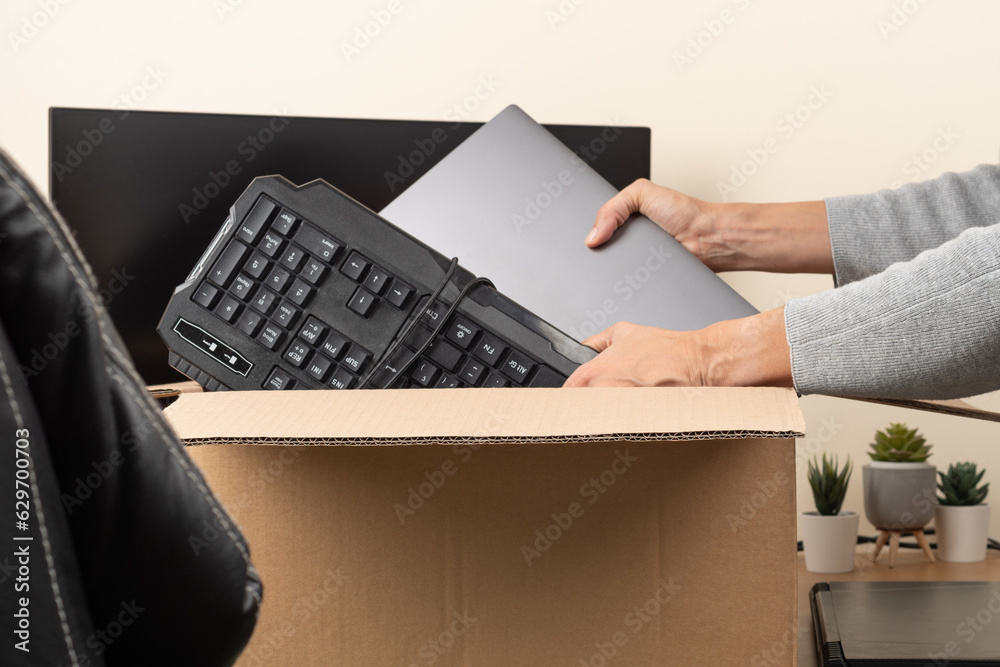 Woman hands put old laptop and keyboard in box with old used computers ...