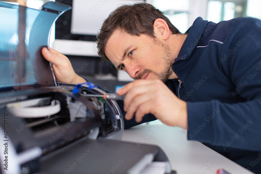 Foto de man is fixing a printer do Stock | Adobe Stock