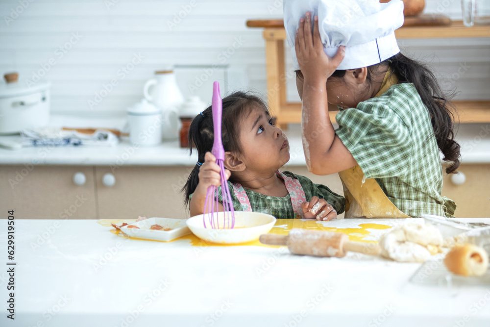 Older sister in the chef's hat has a headache because her younger ...