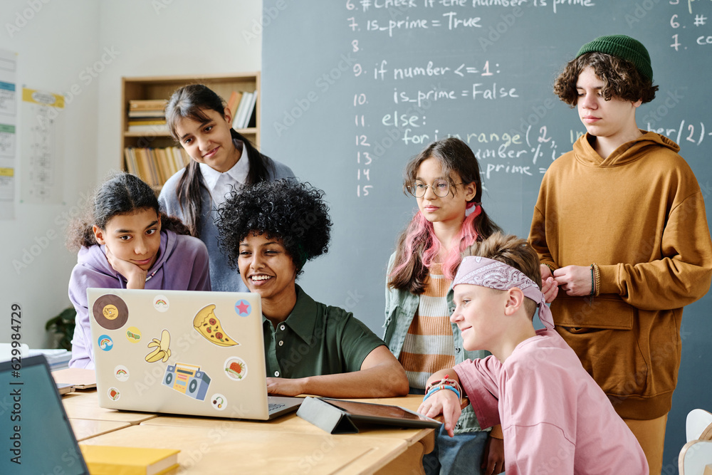African American teacher using laptop to teach students information ...