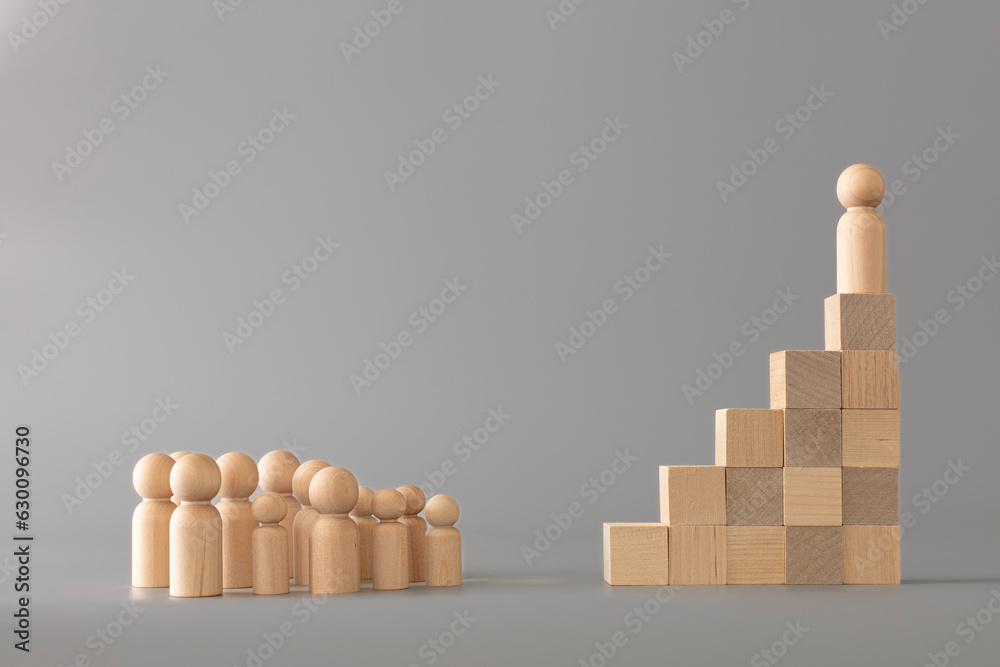 Leader figure standing out from crowd on wooden cubes, other figures in ...