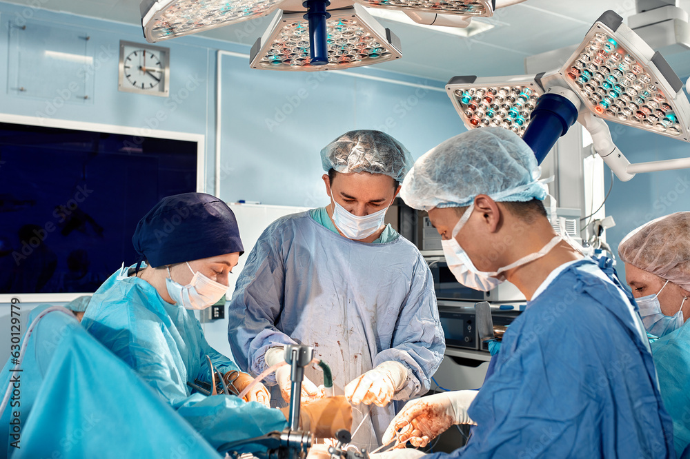 Surgeons team during complex surgical operation in a sterile operating ...