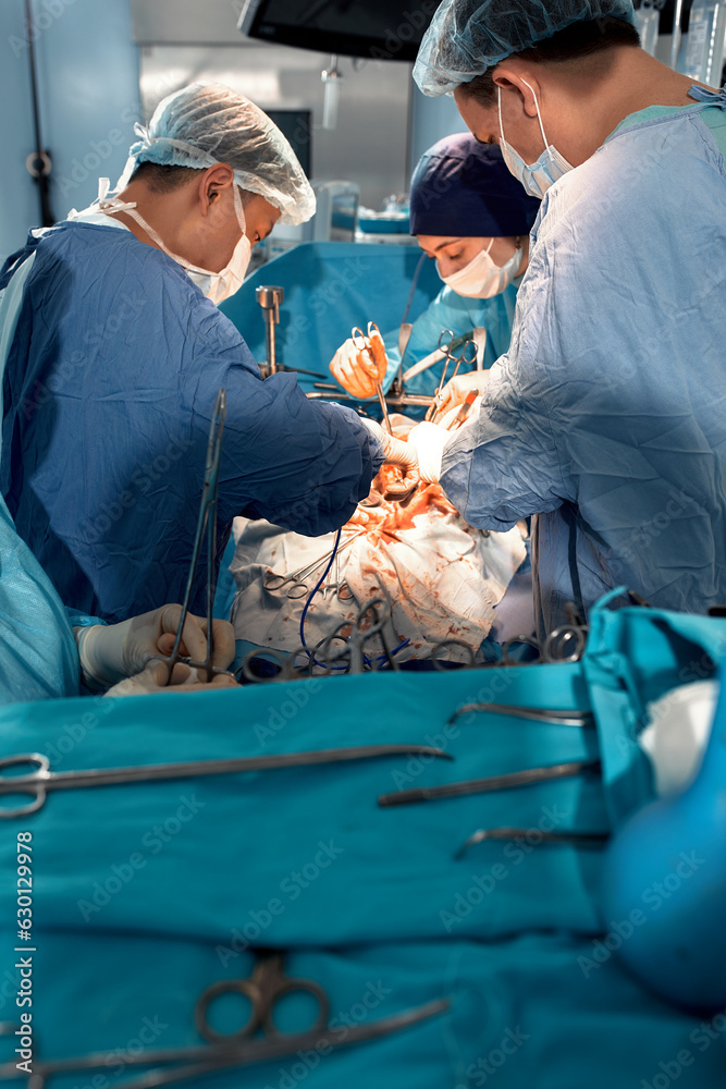 Surgeons team during complex surgical operation in a sterile operating ...