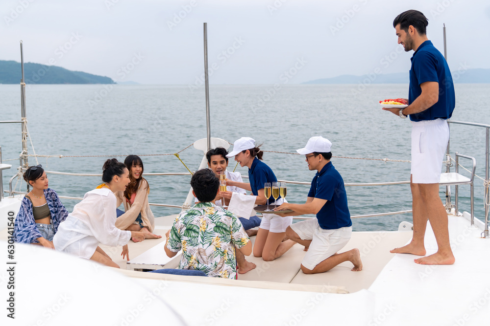 Yacht crew serving fruit and champagne to passenger tourist during ...