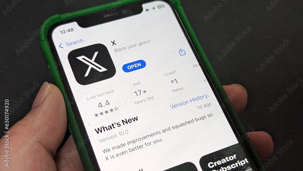 X(Twitter) app on iOS app store on the screen of holding smartphone ...