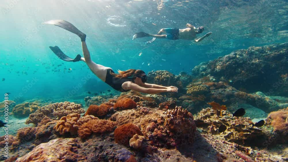 Couple freediving. Young fit freedivers man and woman swim underwater ...