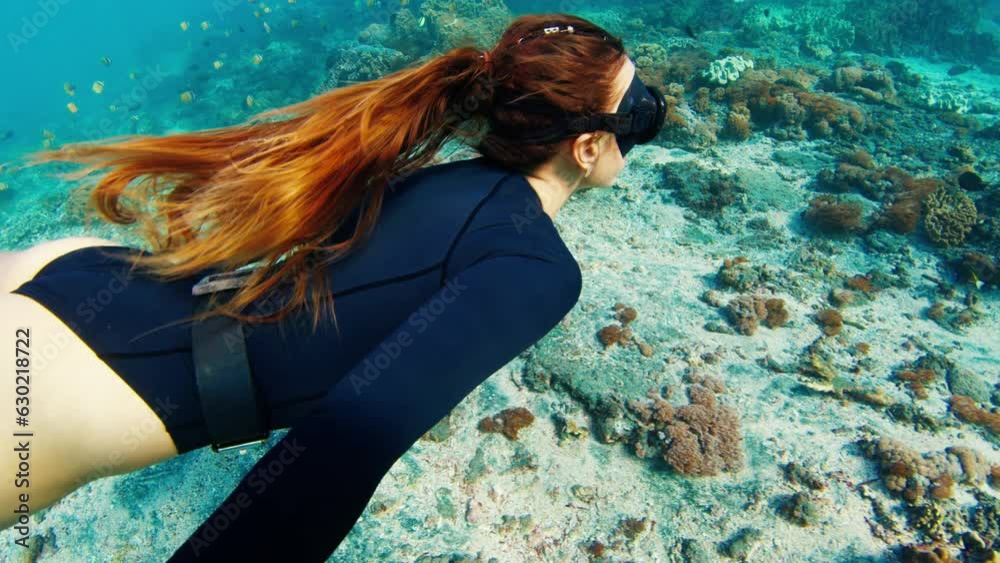 Woman freediver on reef. Young female freediver swims underwater and ...