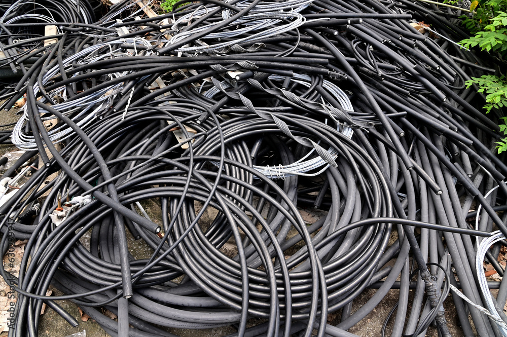 Closeup of Lots of black electric wires laying in piles on the concrete ...