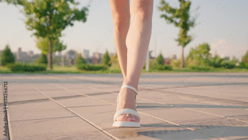 Seductive Female Legs In High Heeled Sandals Gracefully Walk Through The Sunny City Park Sexy