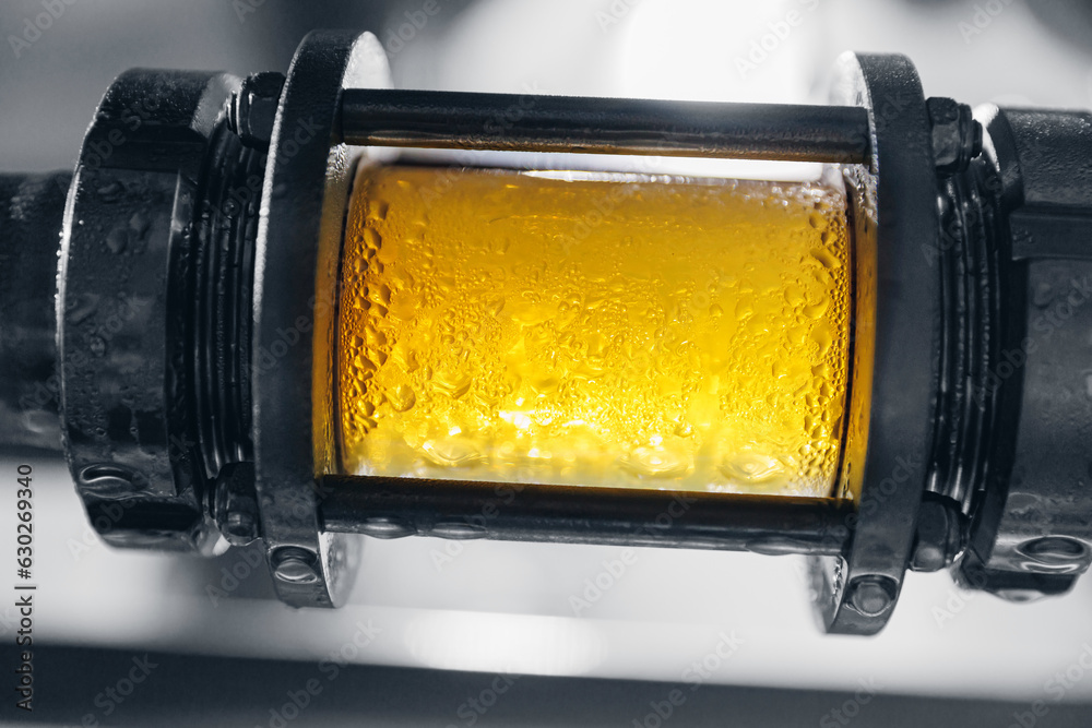 Brewing equipment for quality control, sight glass full of golden beer ...